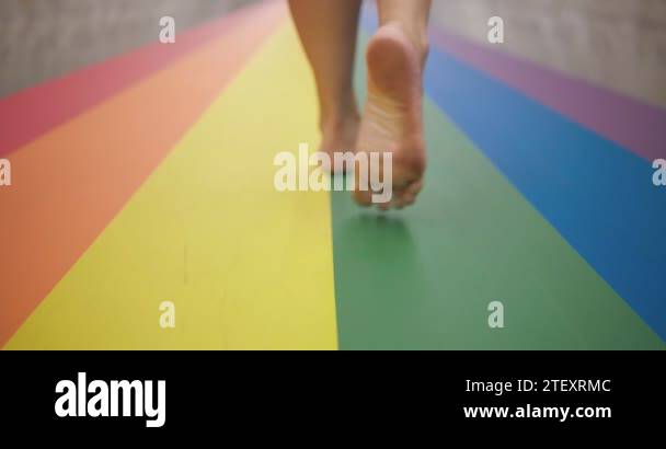 Slow motion of feet walking barefoot on LGBT rainbow colored crosswalk ...