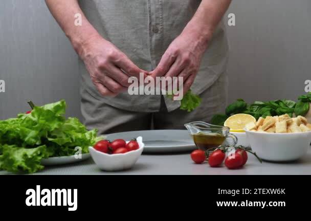Male chef prepares a healthy and delicious vegetarian Caesar salad. The ...