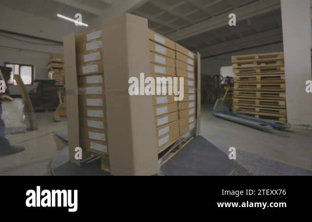 A special machine wraps boxes in polyethylene film. Packaging boxes ...