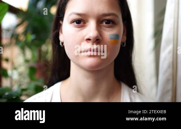 Young sad Ukrainian girl with the flag of Ukraine and Russia on her ...