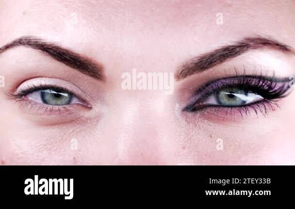 Close-up woman face - one eye with fancy arrow make-up, another without ...