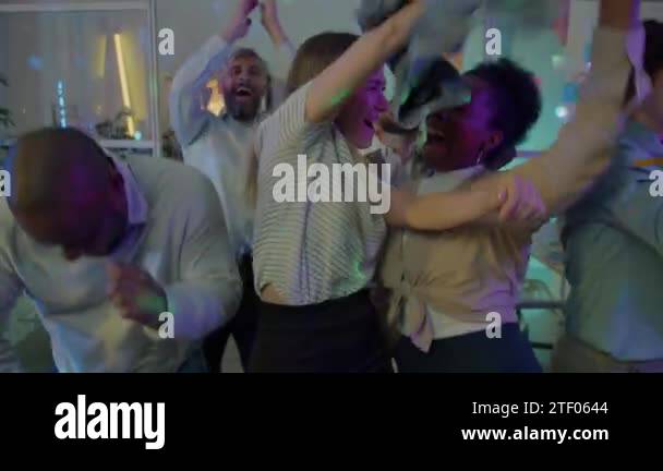 Drunk office workers diverse group dancing laughing and fooling around ...