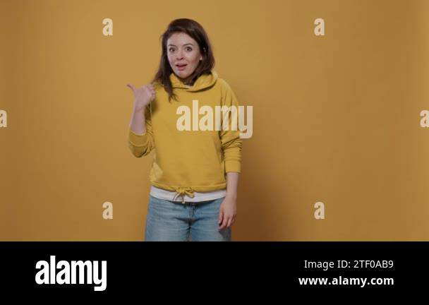 Funny smiling expressive woman doing mocking gesture with thumbs up ...