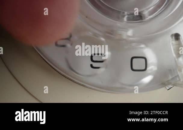 Male finger rotating the dialer. Man is dialing phone number on an old ...