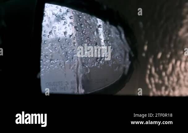Worker sprays water on side mirror from pressurized jet. Waterdrops ...