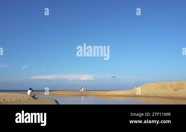 4K Airplane landing in clear blue sky background flying overhead ...