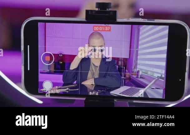 queer non-binary person creates a vlog with smartphone, shopping haul ...