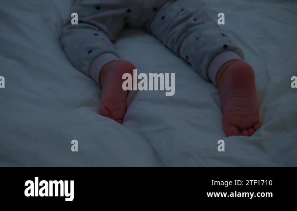 young mother reading book of fairy tales to little sleeping baby girl ...