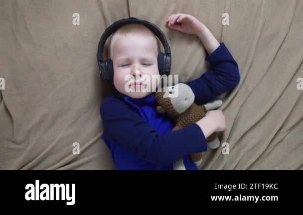 Boy in headphones listens to a meditation for children before going to ...