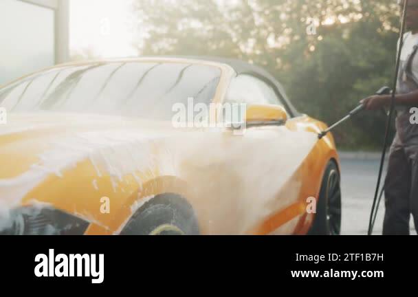 African stylish young focused man in work clothes washing his modern ...
