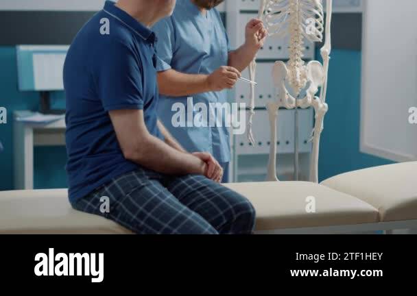 Osteopathy specialist explaining spinal cord system on human skeleton ...