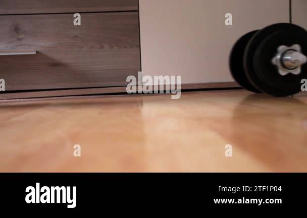 Male hand picking up heavy barbell rolling into view for heavy weight ...