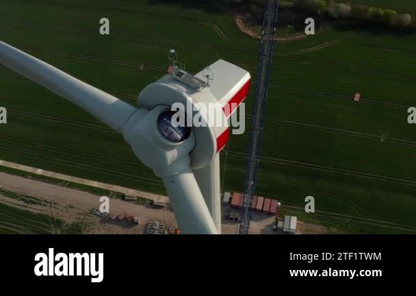 Fly around large generator of wind turbine under construction. Propeller without one blade ...
