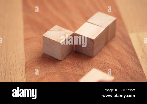 Making a check mark from wooden toy cubes. Hand moves wood block ...