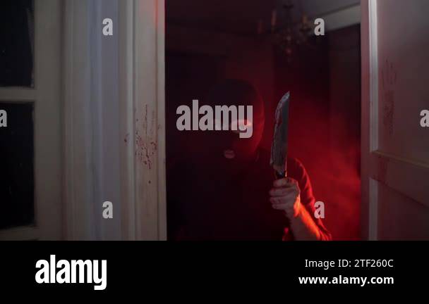 Serial killer in balaclava mask haunting his victim with bloody knife ...