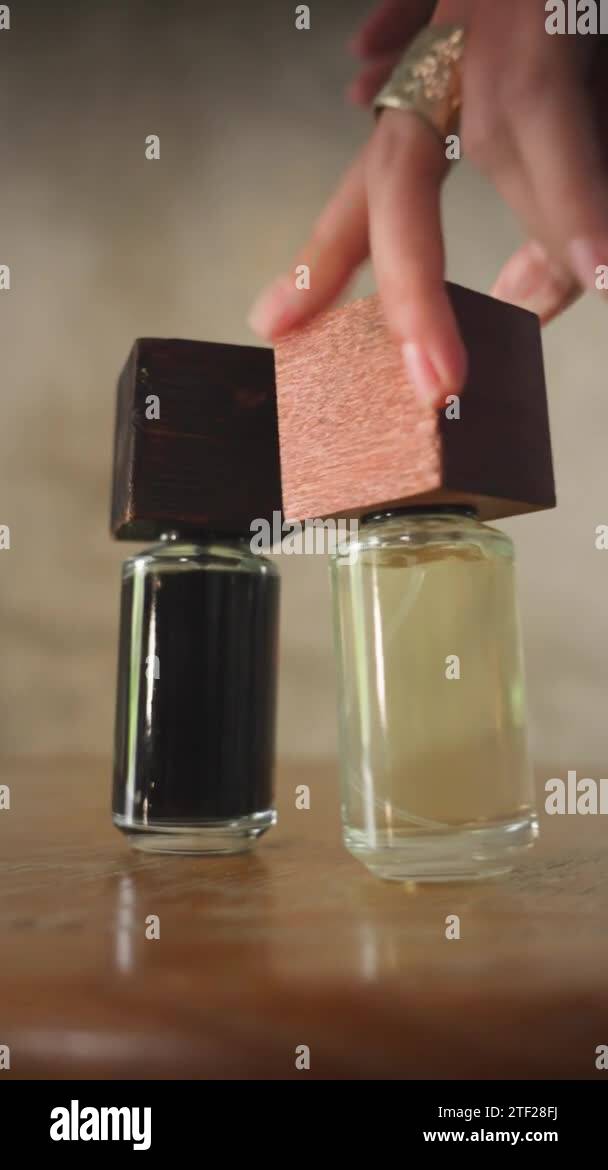 Hands with rings put brutal perfume bottles in the frame. Bottles in ...