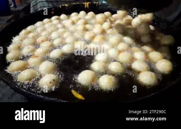 Gulab Jamun, an Indian sweet is being made in a sweet shop. This sweet ...