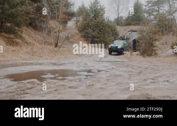 Heavy military 4x4 truck with soldiers and machine gun crossing the mud ...
