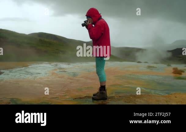 dramatic iceland landscape, geothermal steam smoke rising, one person ...