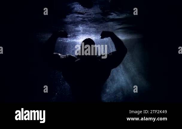epic male figure in dark depth of sea, powerful bodybuilder is showing ...