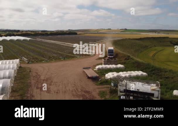 Drone view in Scotland, a double-decker bus arrives at a greenhouse ...