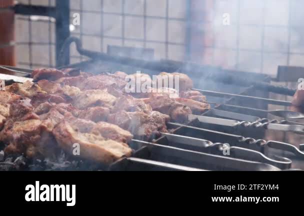 a man roasts meat on a fire. Close-up of hands and barbecue. Grilling ...