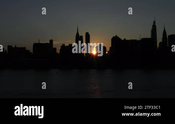 slow trucking shot along silhouetted buildings at gorgeous sunset, at ...
