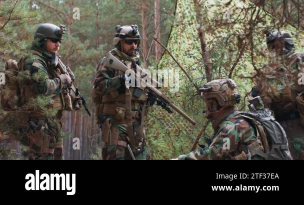 Bearded soldiers in woodland uniforms with helmets on their heads and ...