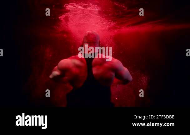 bodybuilder is floating underwater, rear view on muscular male figure ...