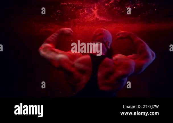 brawny bodybuilder is showing his muscular back and arms, floating ...