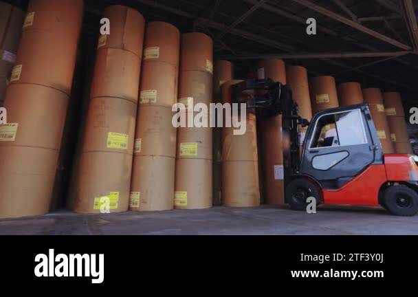 The forklift is carrying a large roll of paper. A forklift is carrying ...