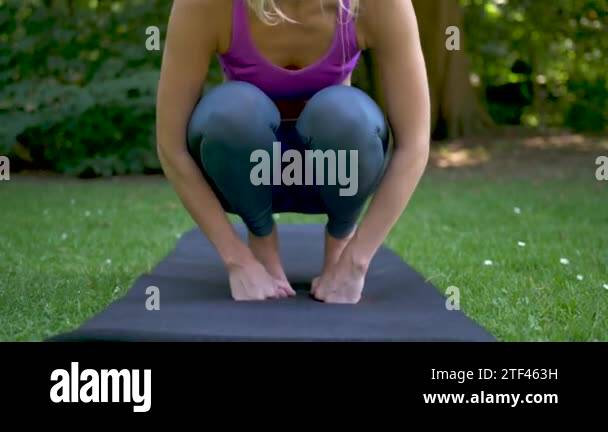 Pretty, fit woman with long blonde hair demonstrating a forward bending ...