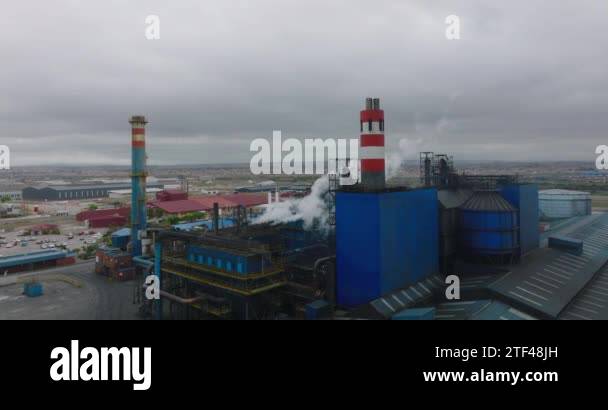 Fly around factory. Industrial buildings with chimneys and emitted ...