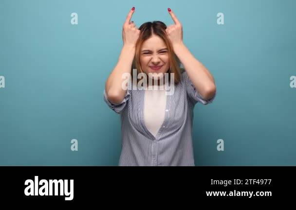Bully woman looking threatening and showing bull horn sign, holding ...