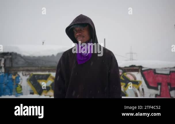 Rapper singer raps on street in winter, rushes his hands and looks at ...