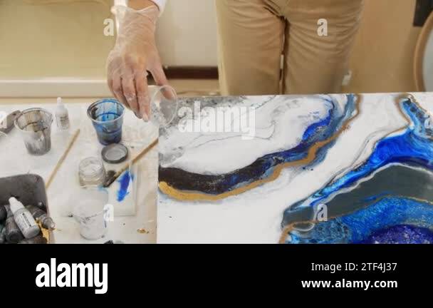 Epoxy design - adding texture with clear pieces to an epoxy resin painting Stock Video Footage ...