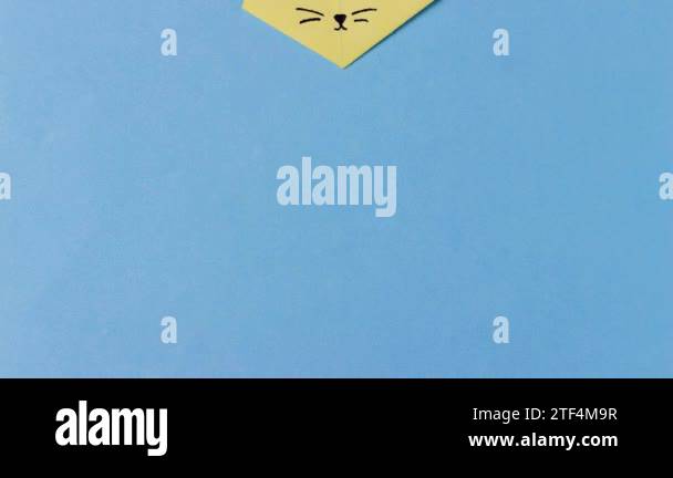 The cats head is folded from yellow paper in the technique of origami ...