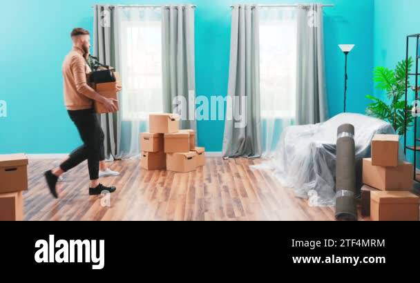 Happy married 20s couple move into new first house bring carton boxes ...