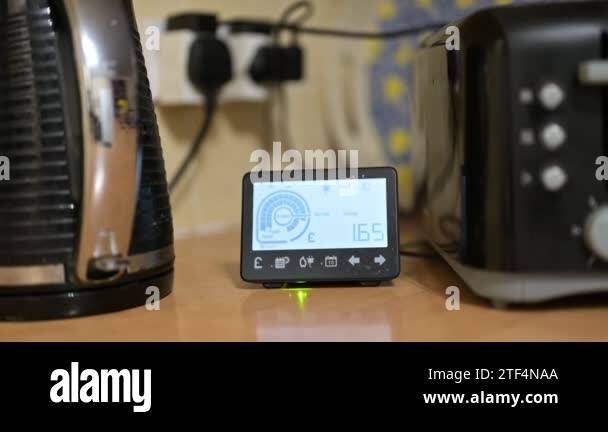 Slow pull out from a smart meter between a kettle and a toaster Stock ...