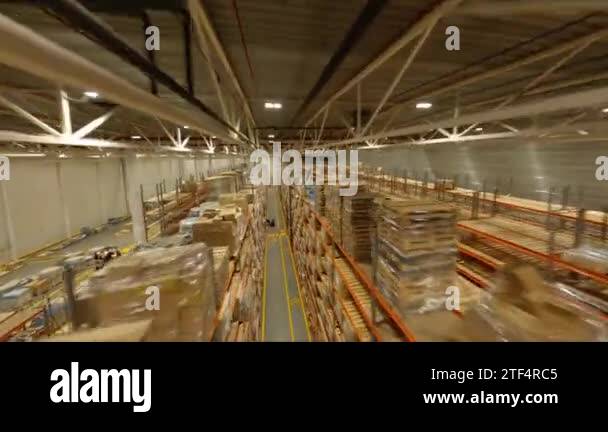 Aisle between high racks with packed products in production plant ...