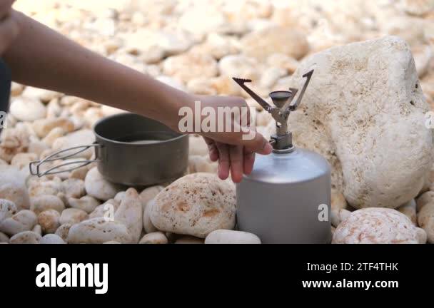Young Hiker Woman Lights Gas burner Stove. Cooking Food Outside ...