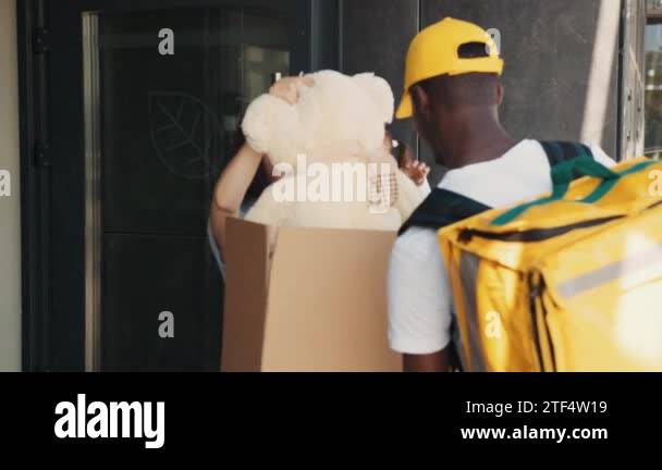 Courier bring a parcel to a little girl with mom at the door of the ...