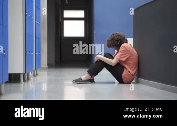 Sad teenager student sitting alone on floor victim of bullying and nice ...