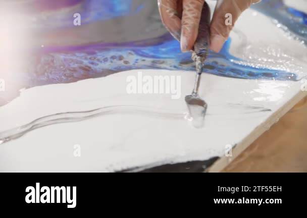 Epoxy design - smearing white epoxy resin on painting using a spatula ...