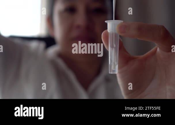 Asian woman do Covid ATK antigen nasal self test kit mixing liquid from ...