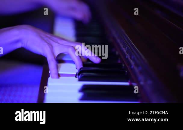 Close-up female hands playing the piano. Fingers on piano keys ...