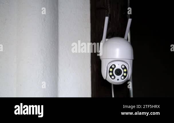 White CCTV camera with antennas rotates and records moving objects ...