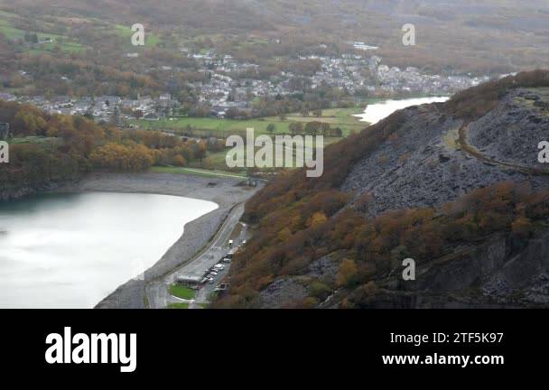 Welsh town Llanberis in Snowdonia National Park high angle tilt down to ...