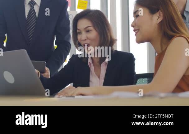 Happy successful Asian business team gives high five. A group engaged ...