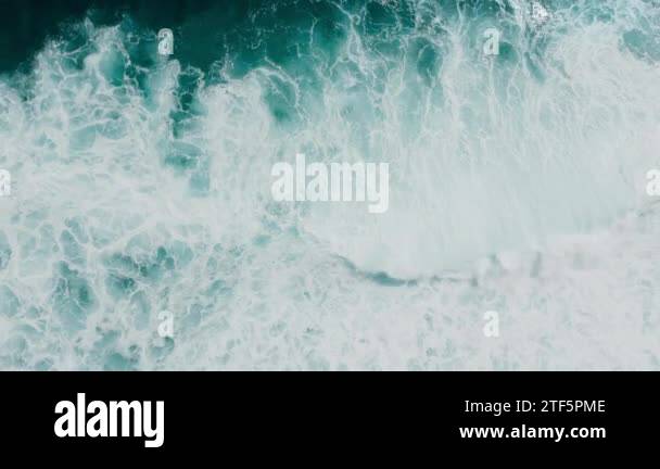 zoom out on the big power ocean waves with white wash. Aerial top view ...